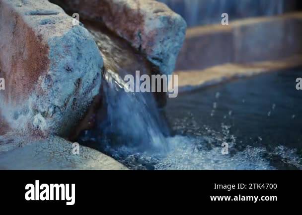 Natural hot spring water flowing into stone bath at Japanese onsen ...