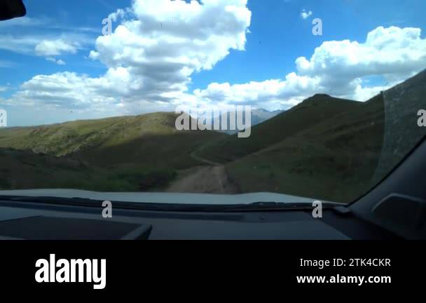 Drive an SUV through the hills of the mountains. A white car drives ...