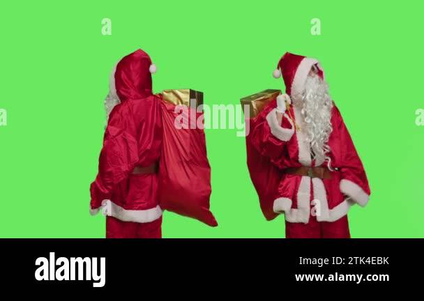 Santa claus doing push gesture in studio, having sack full of gifts ...