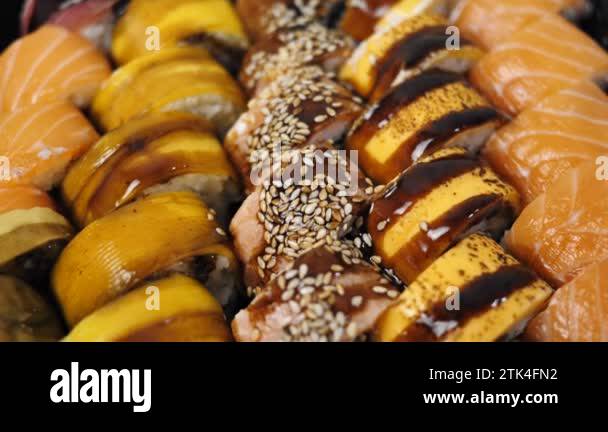 Different sushi rolls rotating close-up on a black background. Fresh ...