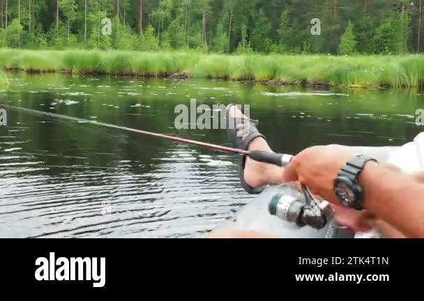 Spoon-bait. A fisherman with hairy legs and arms, sitting in a boat ...