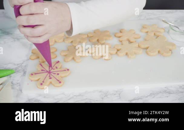 Step by step. Icing snowflake shaped sugar cookies with pink royal ...