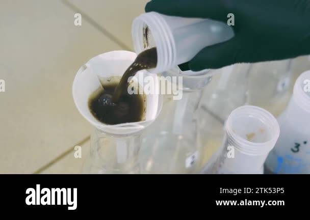 Agrochemical Analyst pouring Soil Samples Mixed with Extracts into Lab ...