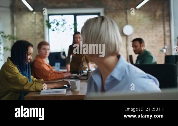 Businesswoman sharing business victory with office team sitting ...