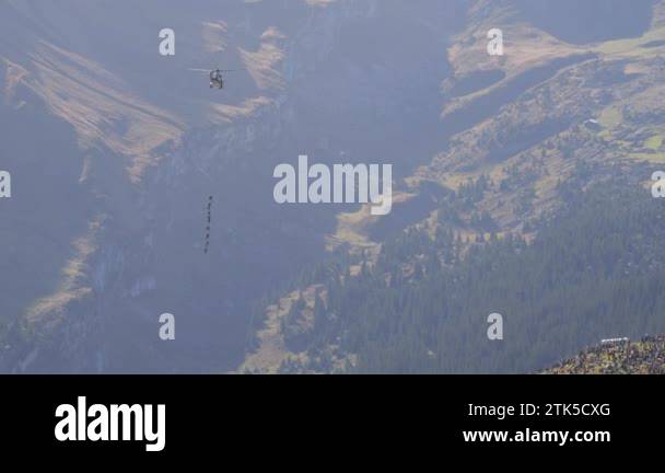Military helicopter in flight at high speed in a narrow mountain valley ...