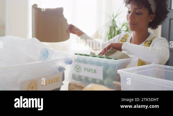 Video of happy biracial woman sorting recycling and smiling at home ...