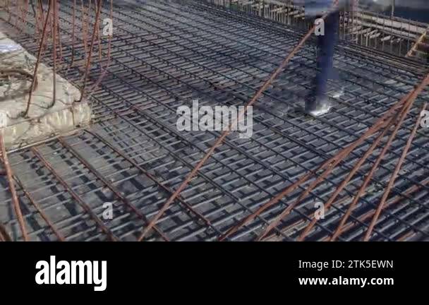 Construction workers working on steel rods used to reinforce concrete ...