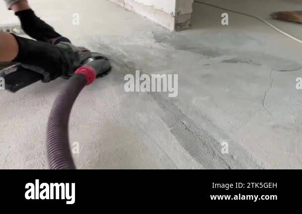 Construction works. Grinding a concrete floor or cement-sand screed to ...