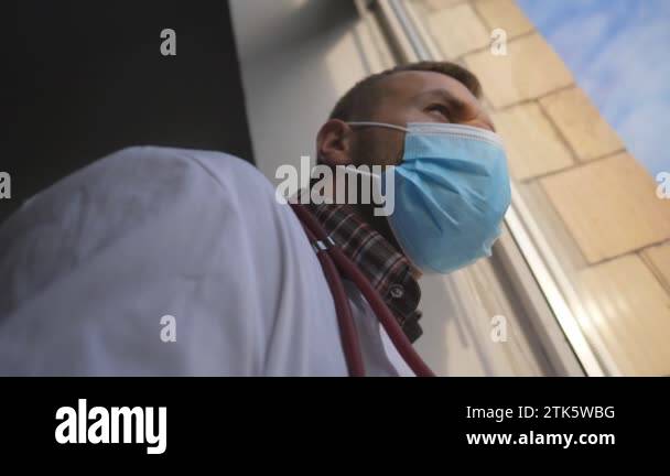 Pensive doctor at medical uniform look of out window. Overworked and ...