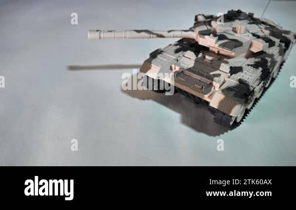 Close-up shot of an isolated radio-controlled toy tank that drives ...