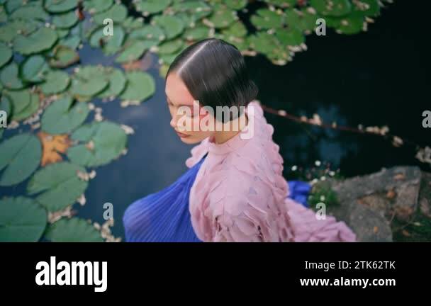 Water fairy sitting on nature pond looking camera with mysterious gaze close up. Mesmerizing ...