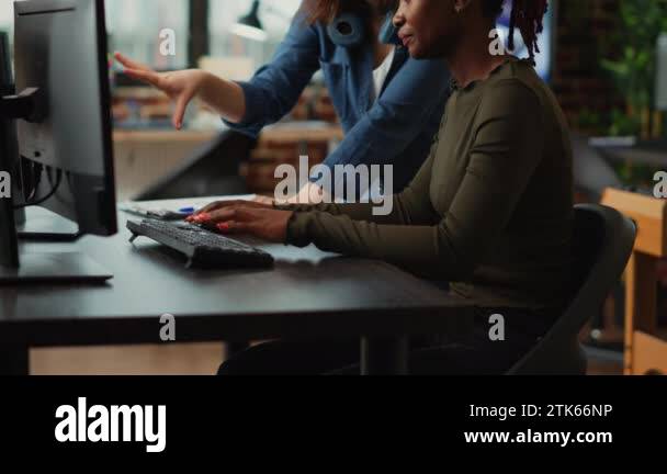 Team of diverse office employees working on multi monitors to create machinery software, using ...