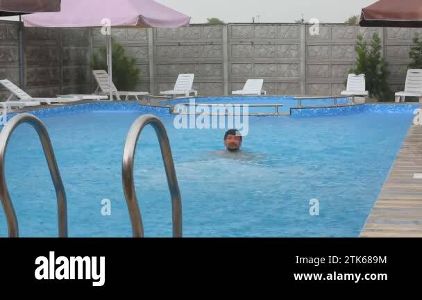 Man floating on water in swimming pool.Young man relaxing in the ...