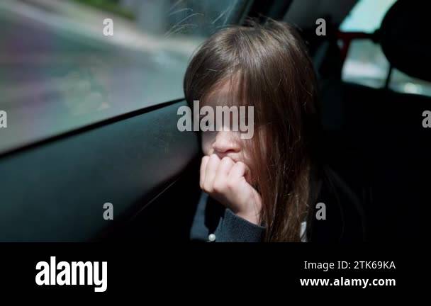 Pensive child traveling by car with sad emotion. Closeup little girl ...