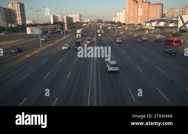 Traffic on an eight-lane asphalt road of cars, trucks, buses. Loaded ...