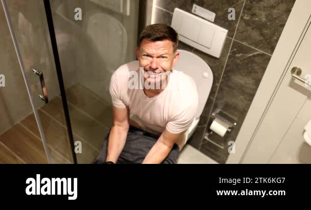 Portrait of man pushing poop in toilet with constipation. Young man ...