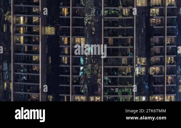 Illuminated panoramic windows in apartments of a high class building at ...