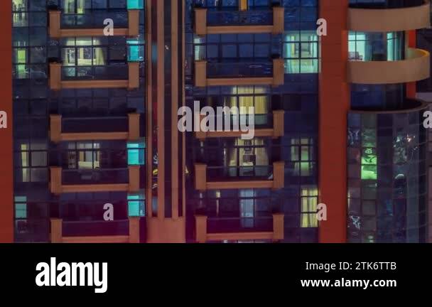 Night aerial view of apartment building glass window facade with ...