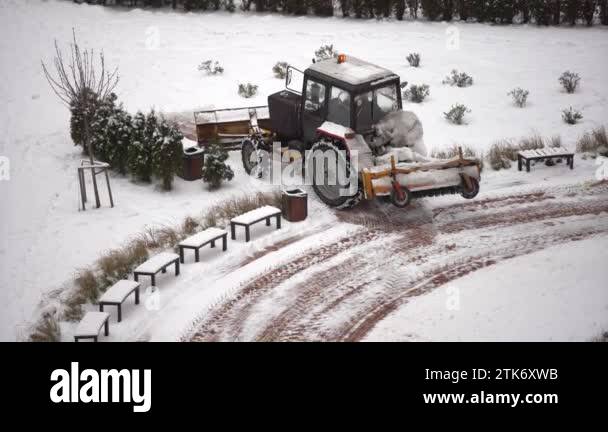 Tractor sweep snow with rotating brush and snowplow from pedestrian ...