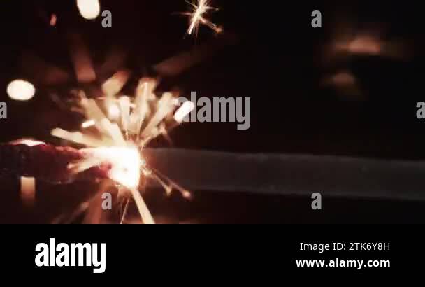 Video of close up of sparkler and copy space on black background. Fire ...
