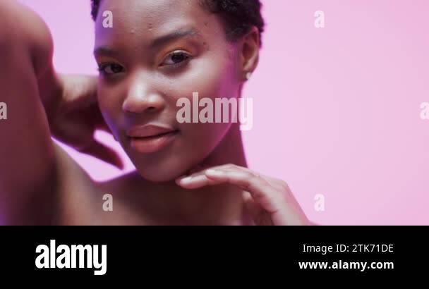 African american woman with short dark hair in blue and pink light ...