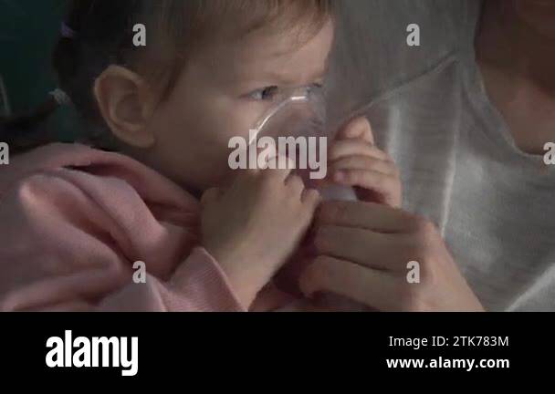 one toddler and mother using nebulizer at home Woman hold her small ...
