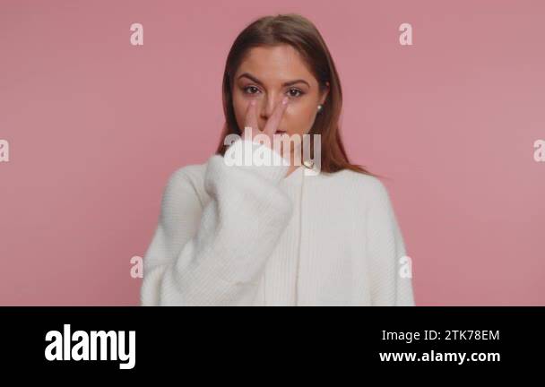 I am watching you. Caucasian woman in white sweater pointing at her ...