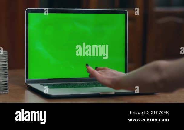 Girl hand pressing key on greenscreen laptop keyboard starting video ...