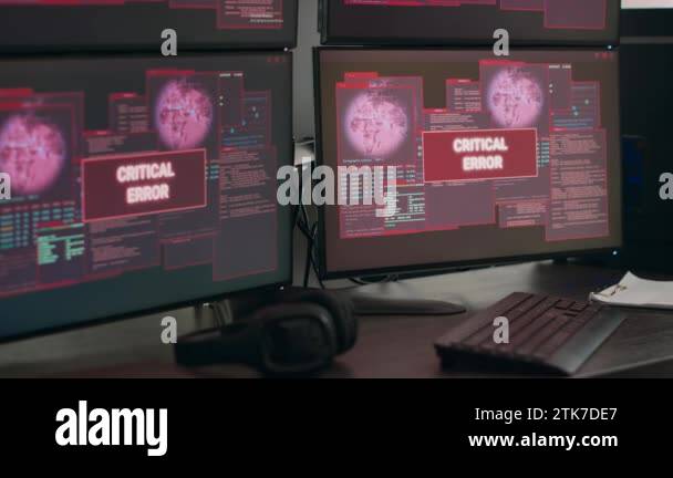 Empty desk with multiple monitors showing system crash warning ... Empty desk with multiple monitors showing system crash warning ...