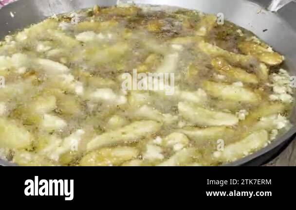 Deep fried sliced banana in hot oil big iron pan. Traditional Thai ...