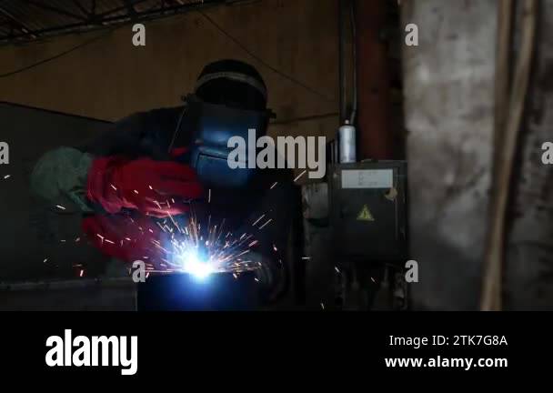 Close-up of a welder welds parts using a semi-automatic welding machine ...