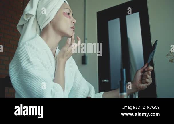 Young asian transgender queer man does his makeup in his room while ...