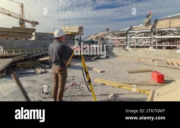 Construction worker using theodolite surveying optical instrument timelapse. Builders and ...