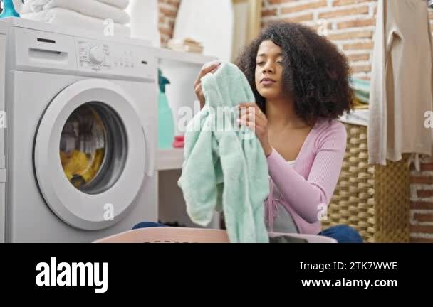 African american woman washing clothes smelling clean towel at laundry room Stock Video Footage ...