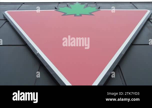 large canadian tire logo against black background with sky above on ...