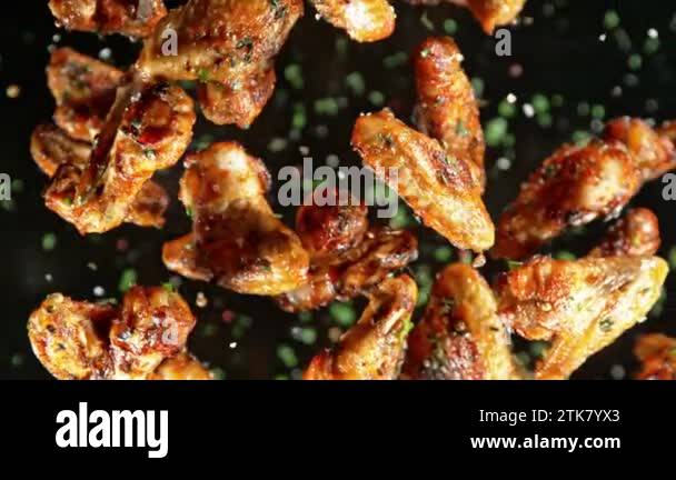 Super Slow Motion Shot of Grilled Spicy Chicken Wings Flying Towards ...