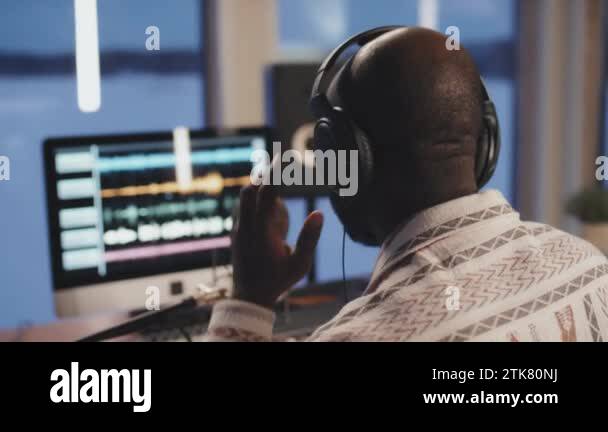 Loose close-up of black man recording audio, singing or saying ...