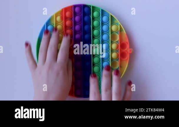 Women hands crumple and play with large round Pop It close-up top view ...