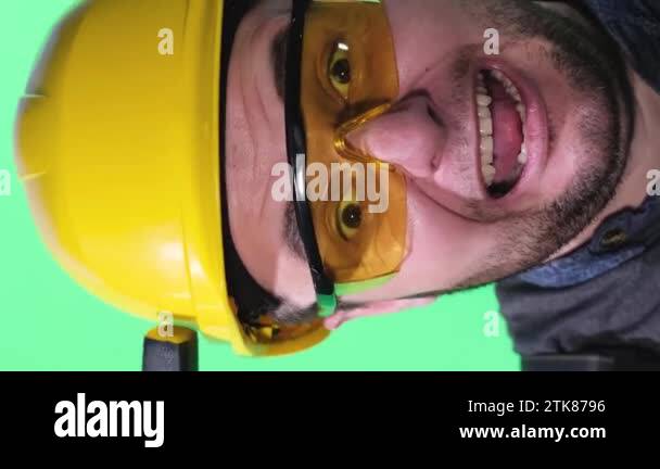 A madly angry construction worker bangs a hammer on his hard hat. Crazy ...