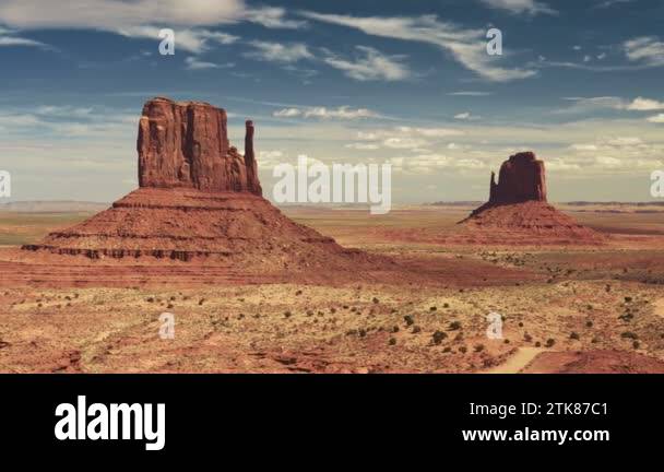 Fancy rock formations under blue sky in Monument Valley. Panning shot ...