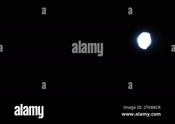 The light of a flashlight into the camera on a black background. Light ...