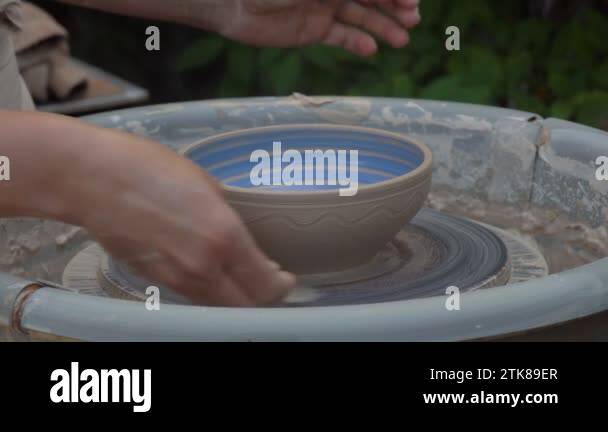 Close-up shot of half-finished ceramic vase spinning on potterss wheel ...