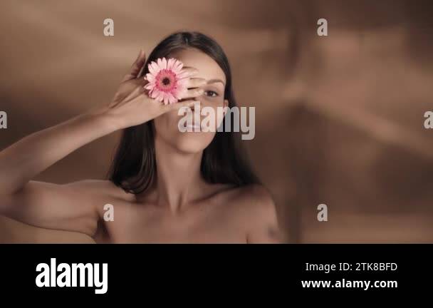 Woman Covering Her Eye With Her Hand With Gerbera Flower Touches To