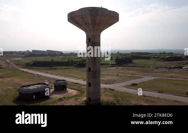 The concrete water tower stands as a silent sentinel of utility and ...