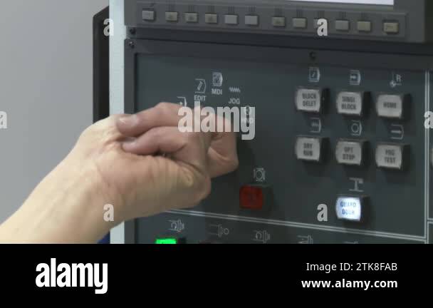 Close up of worker's hands operating the computer controls on a CNC ...