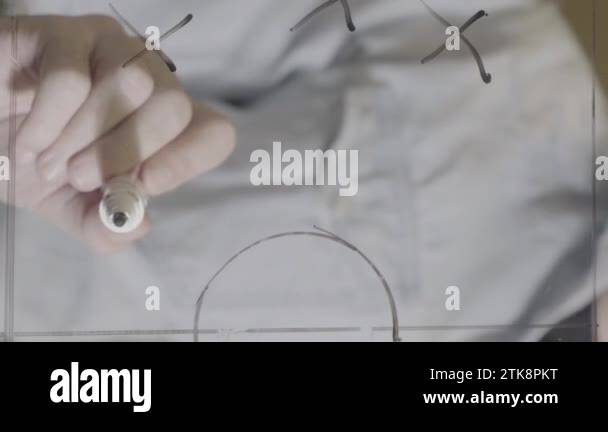 Soccer coach drawing soccer tactics on glass with black marker ...