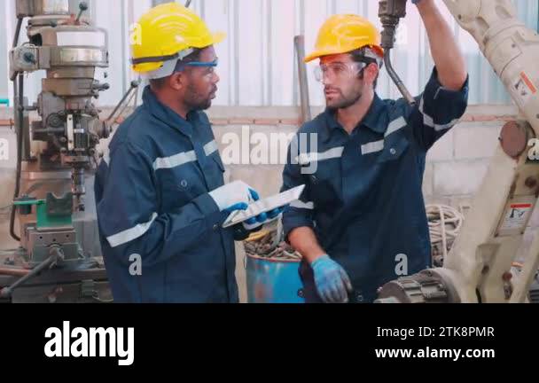 Two young engineer man talking and explaining about robot arms ...