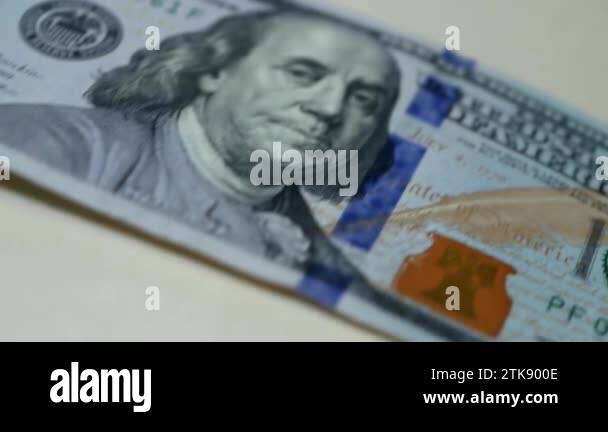 Macro video shooting. Close-up of a hundred dollar bill sliding across ...