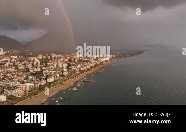 Strong rainbow above the city skyline over the houses and buildings in ...