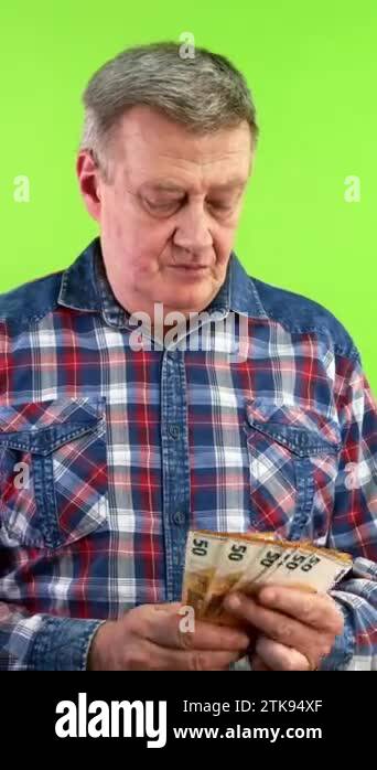 Senior man counting cash of 50 euro money banknotes and smiling pleased ...